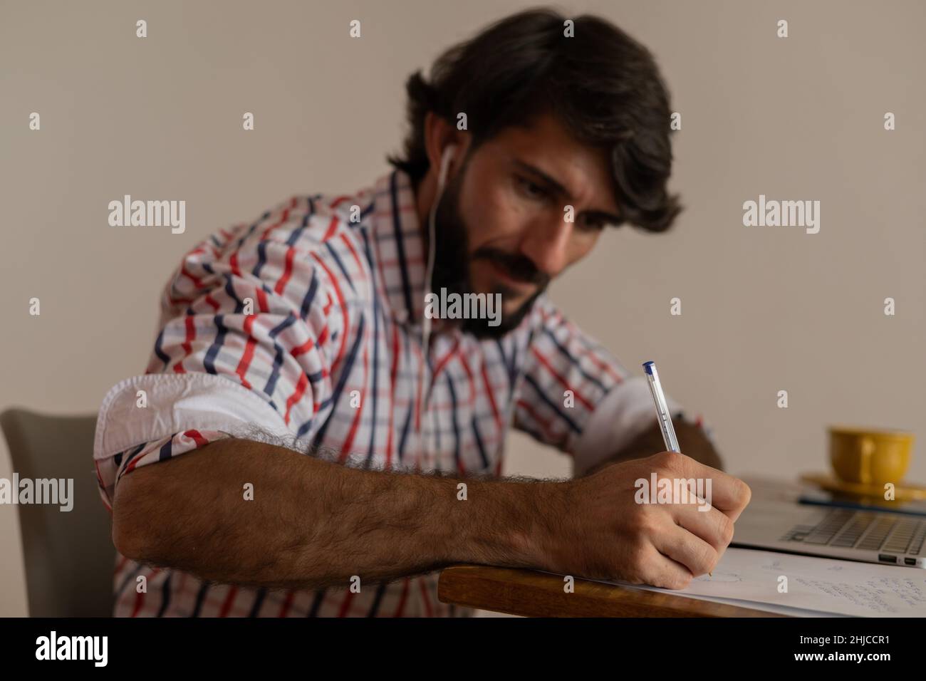 Young business man working at home with laptop on a brown arm chair ...