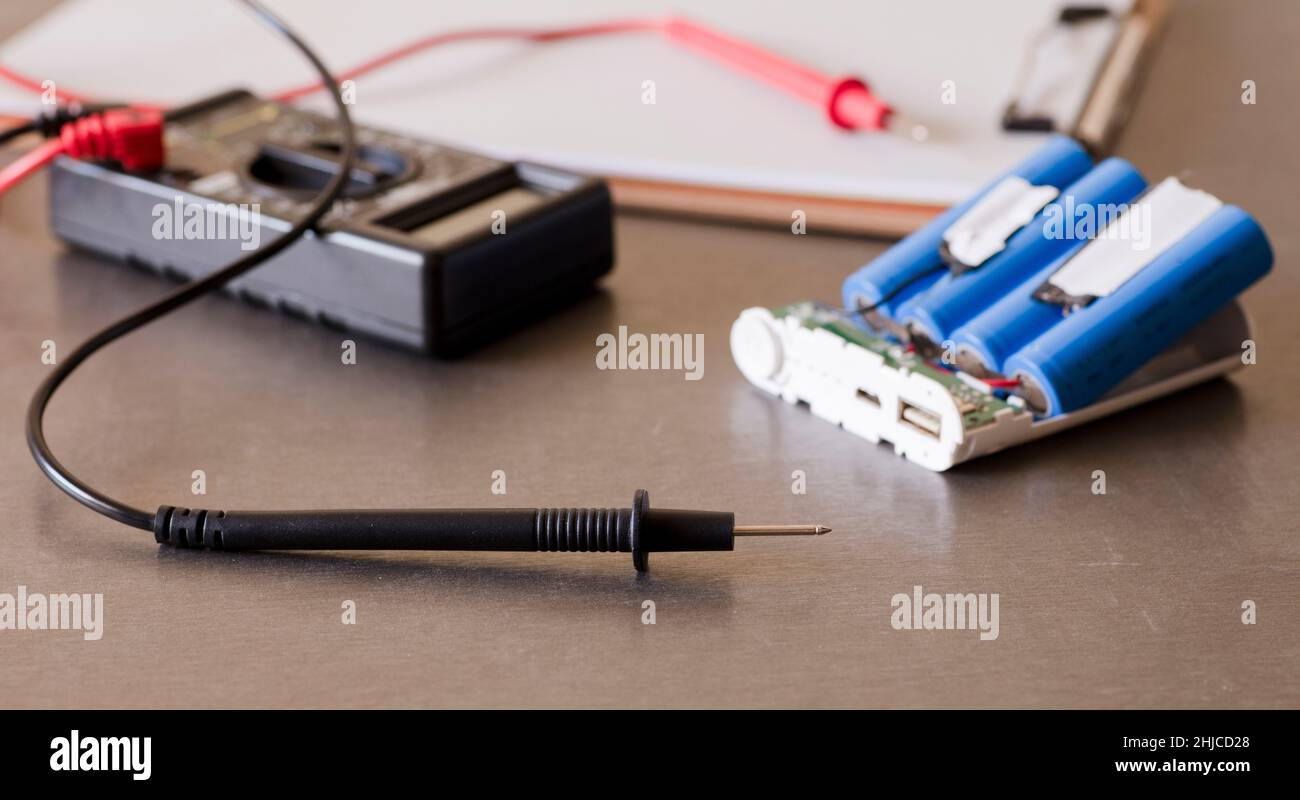 black polymeter work table. in the background multimeter and powerbank ...