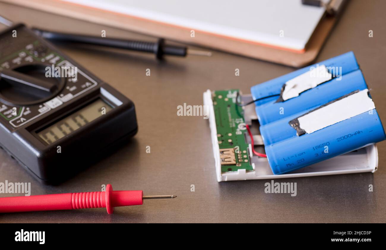 black polymeter work table. in the background multimeter and powerbank ...