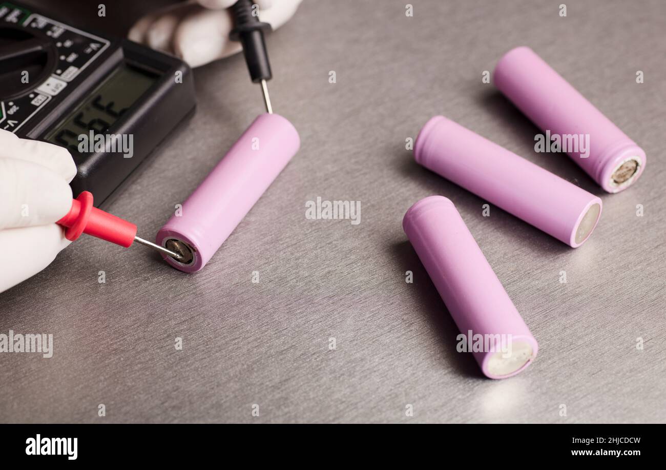 Multimeter red and black poles in the hands of a man checking voltage ...
