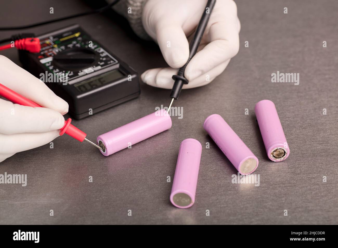 Multimeter red and black poles in the hands of a man checking voltage ...