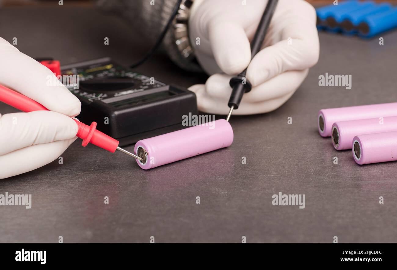 Multimeter red and black poles in the hands of a man checking voltage ...