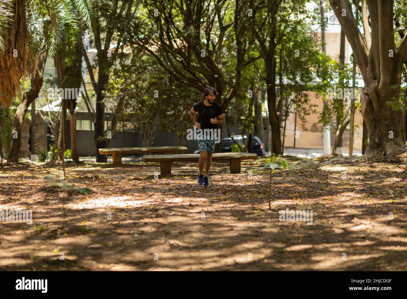 Young guy running and jogging at a park outdoors. Athlete male person ...