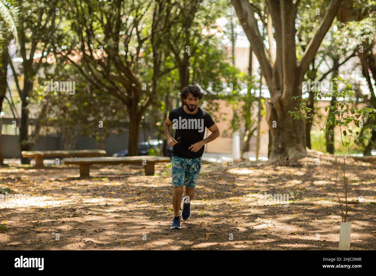 Young guy running and jogging at a park outdoors. Athlete male person ...