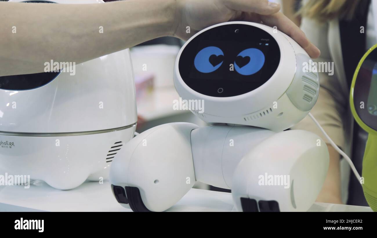 Hand of man touches the robot. Robot is happy with the touch of a human ...