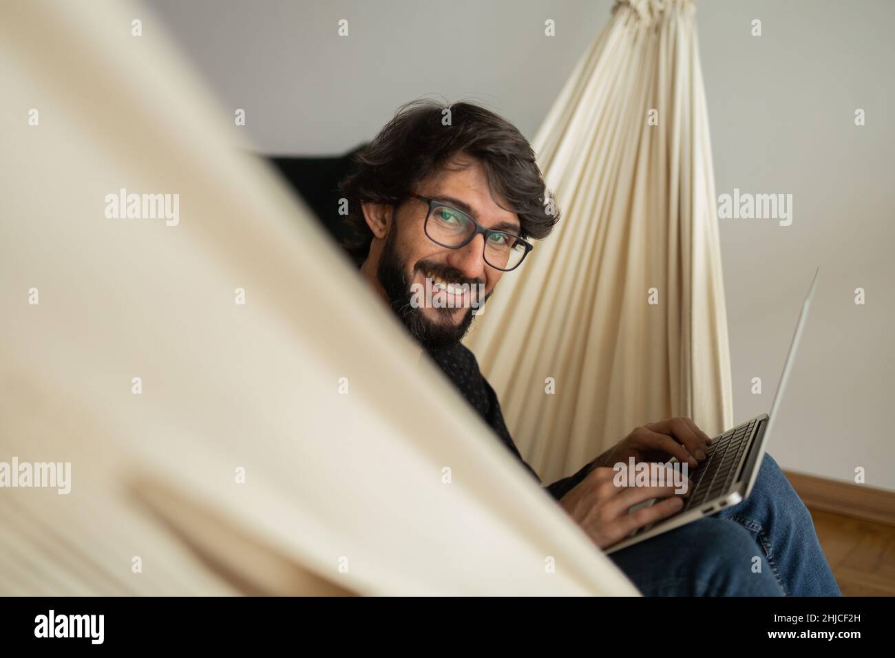 Young business man with black glasses working at home with laptop on a ...