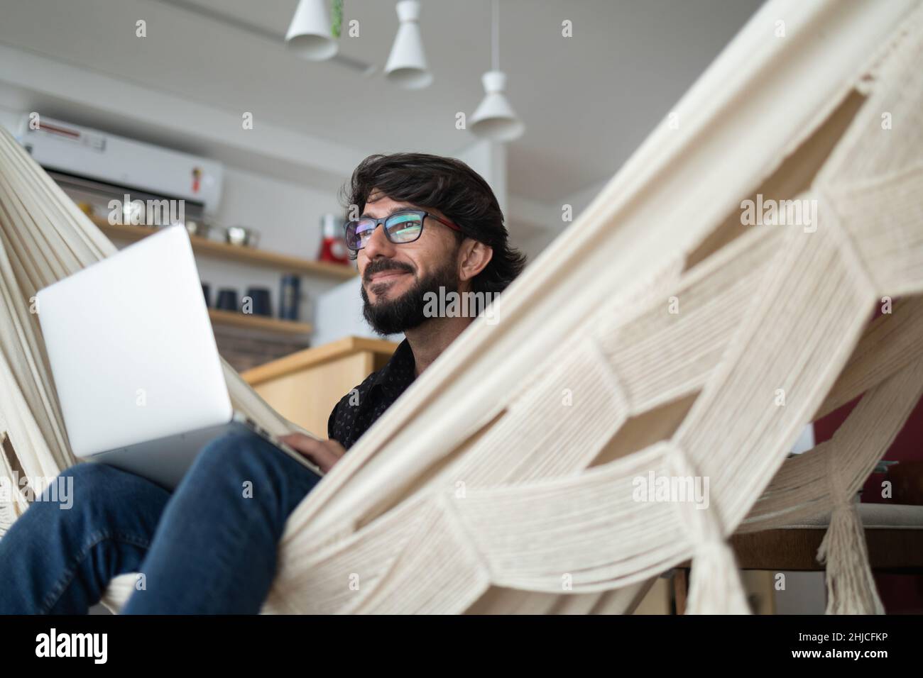 Young business man with black glasses working at home with laptop on a ...