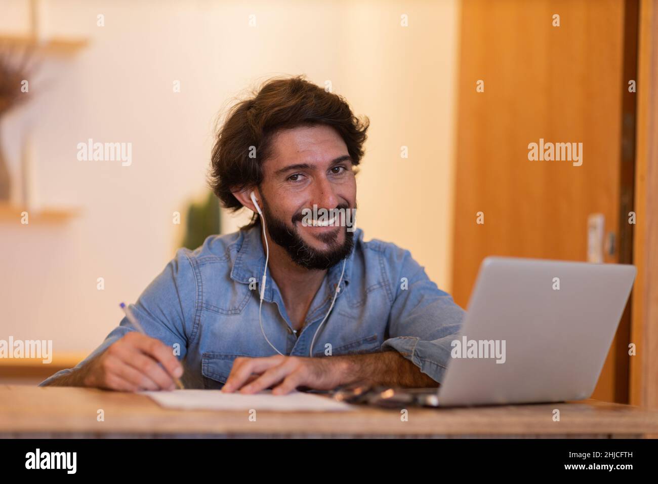 Young business man working at home with laptop and papers on desk. Gray ...