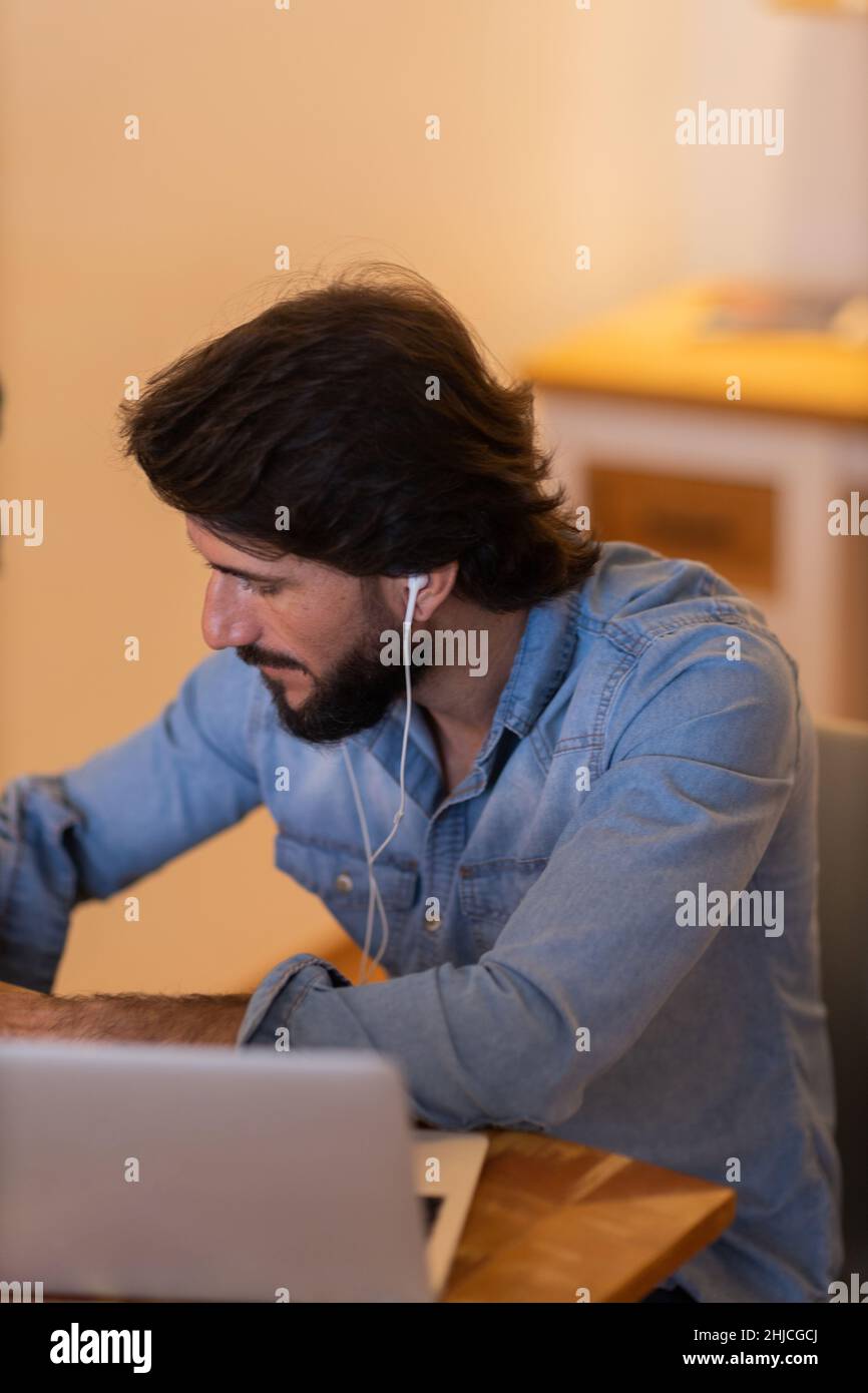 Young business man working at home with laptop and papers on desk. Gray ...