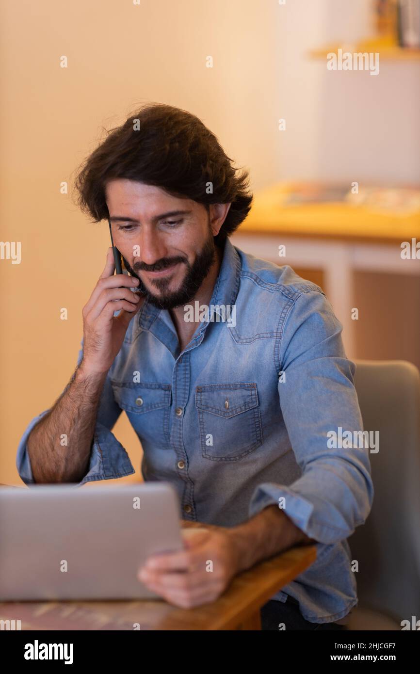 Young business man working at home with laptop and papers on desk. Gray ...
