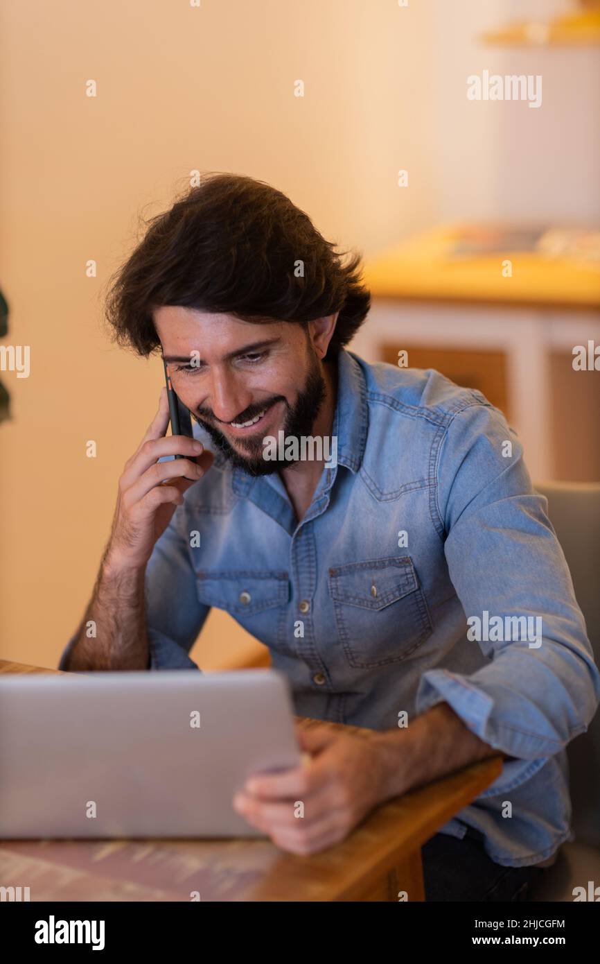 Young business man working at home with laptop and papers on desk. Gray ...