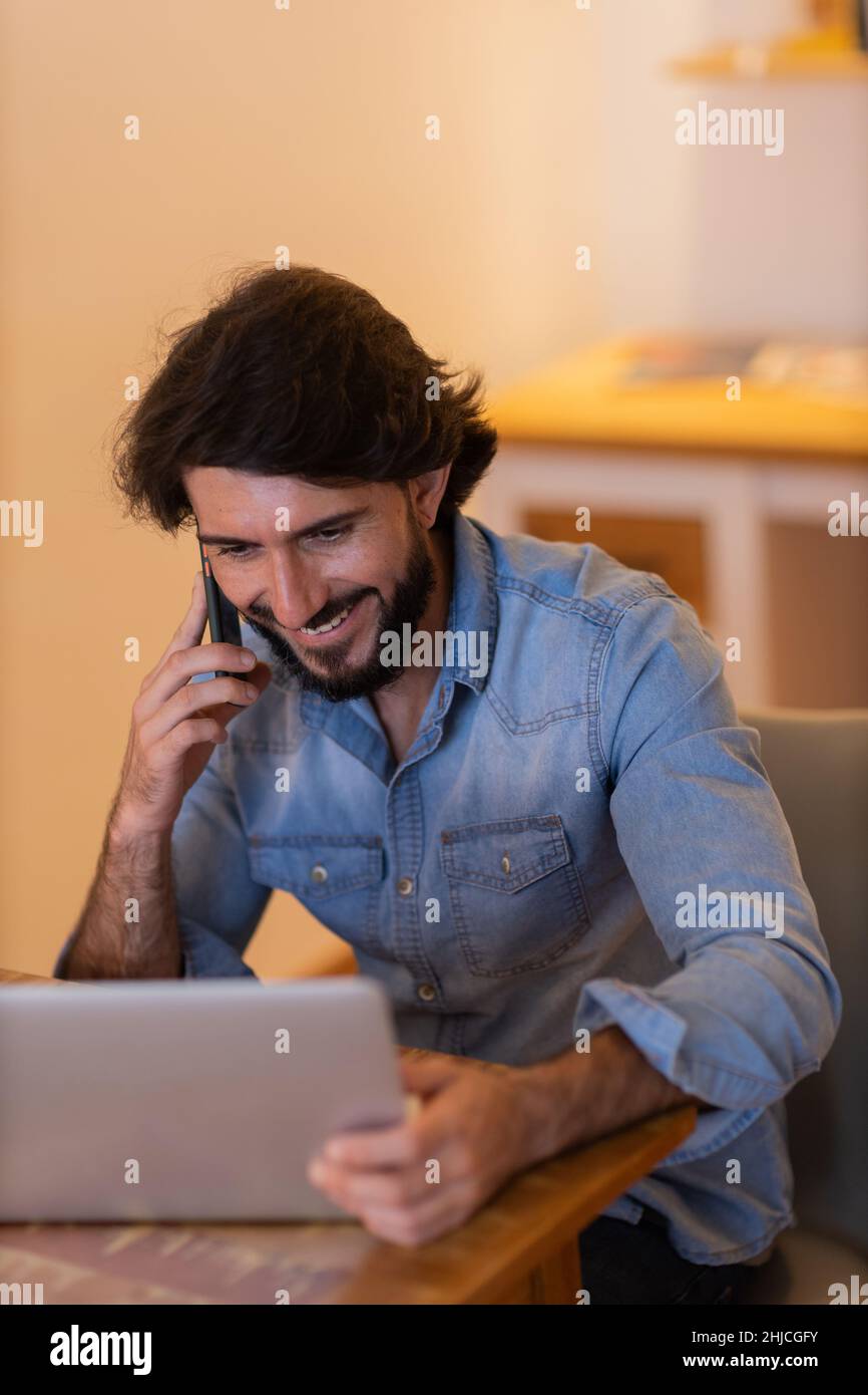 Young business man working at home with laptop and papers on desk. Gray ...