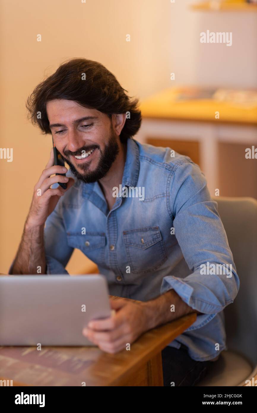 Young business man working at home with laptop and papers on desk. Gray ...