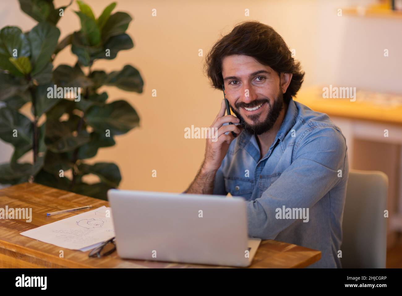 Young business man working at home with laptop and papers on desk. Gray ...