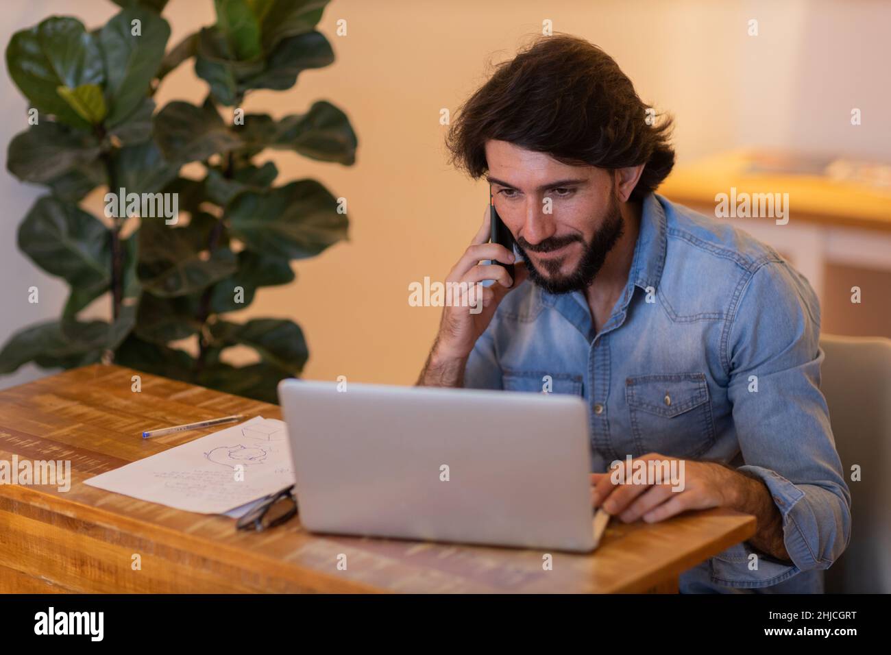 Young business man working at home with laptop and papers on desk. Gray ...