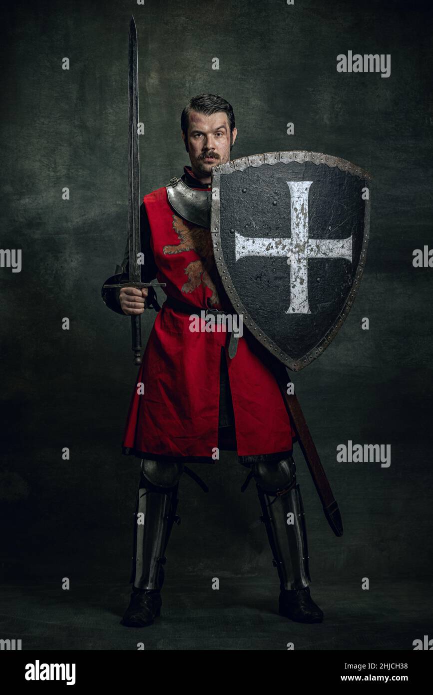 Portrait of medieval warrior or knight with dirty wounded face holding ...