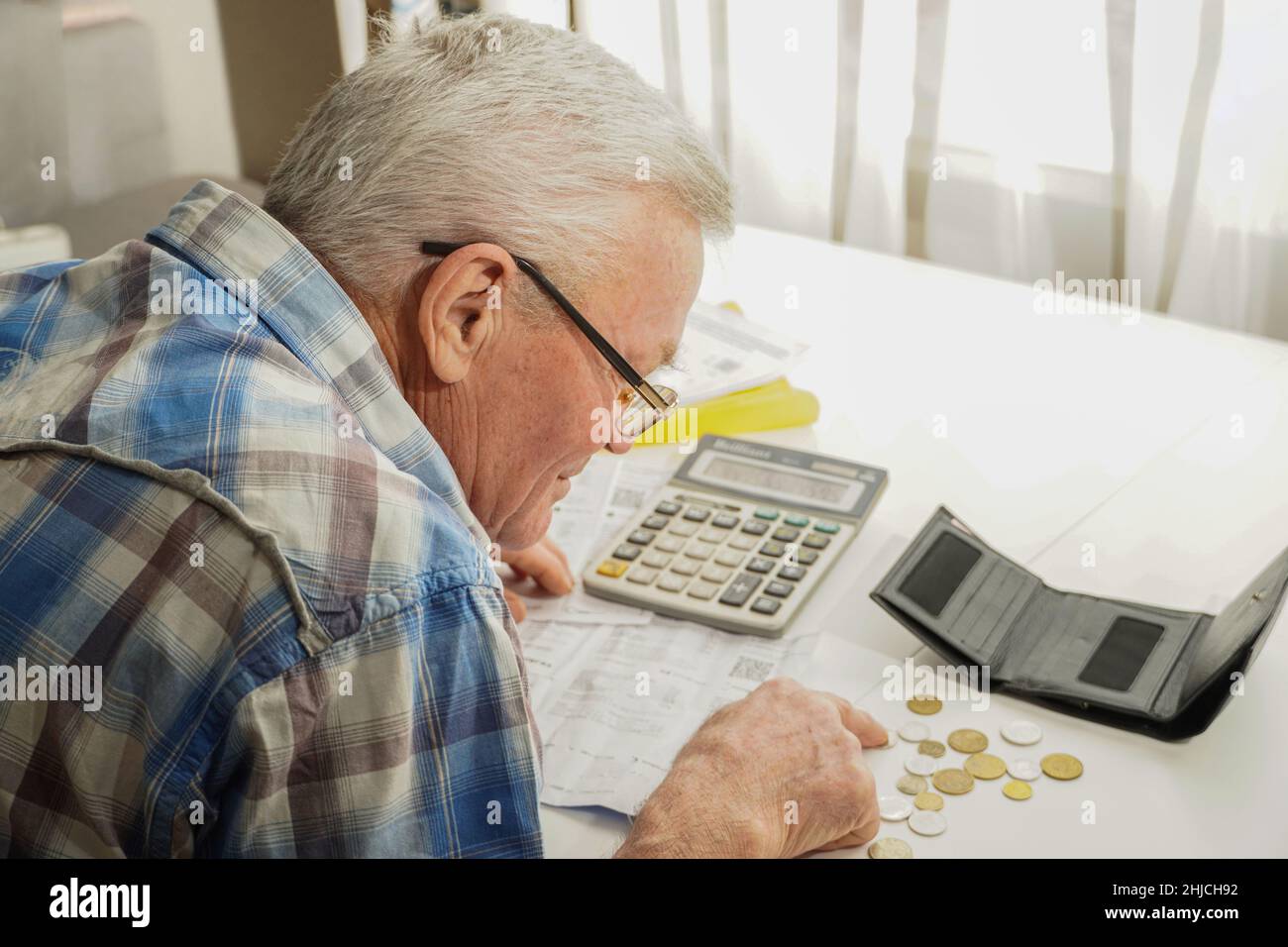Senior man sitting at the table and calculating finances. Old man ...