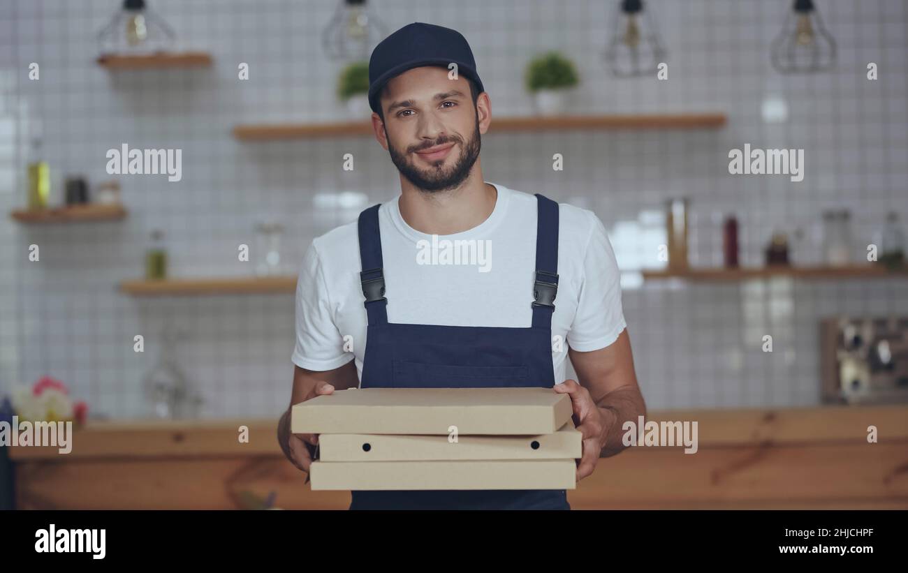 Young delivery man holding pizza boxes at home Stock Photo - Alamy