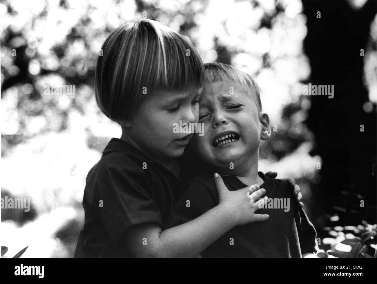 Sister comforts crying brother Stock Photo - Alamy