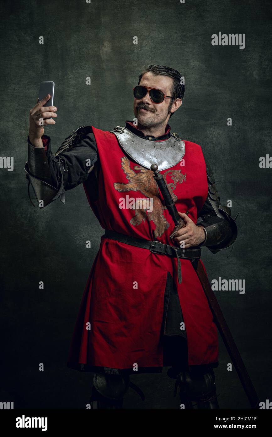 Smiling young man in image of medieval warrior or knight with dirty ...