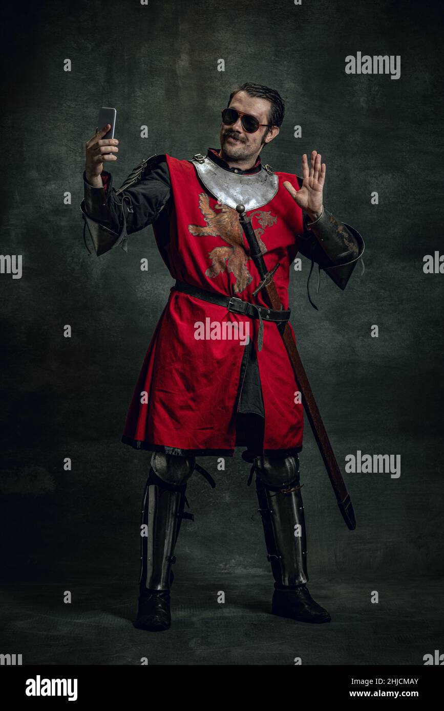 Smiling young man in image of medieval warrior or knight with dirty ...