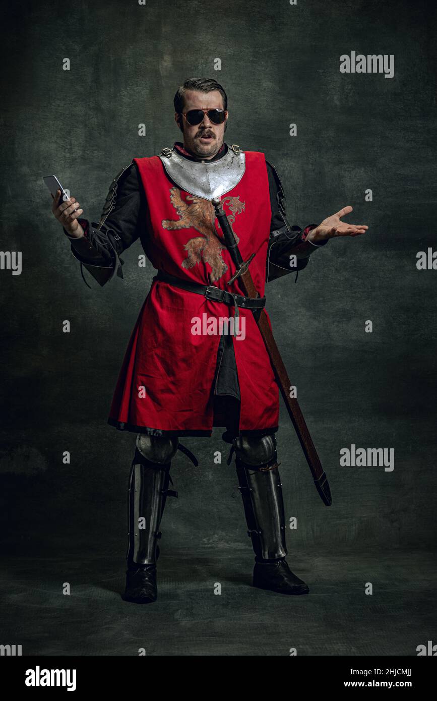 Surprised young man in image of medieval warrior or knight with dirty ...