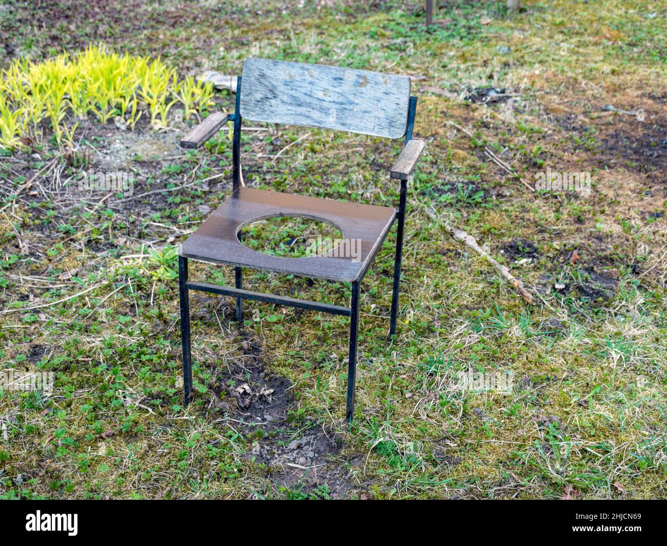 picture with a wooden chair, a hole in the middle of the chair to fit a ...