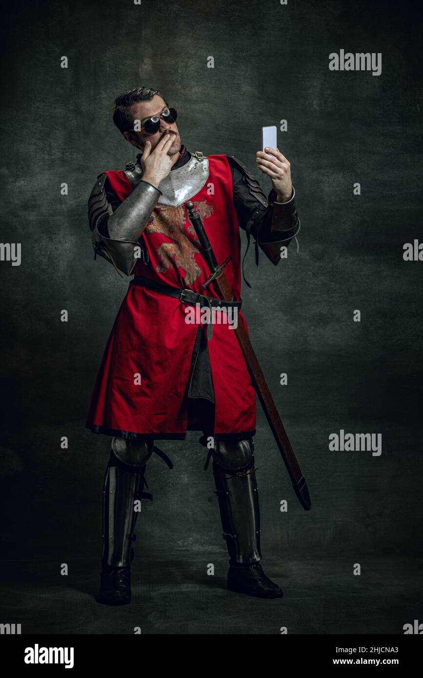 Smiling young man in image of medieval warrior or knight with dirty ...