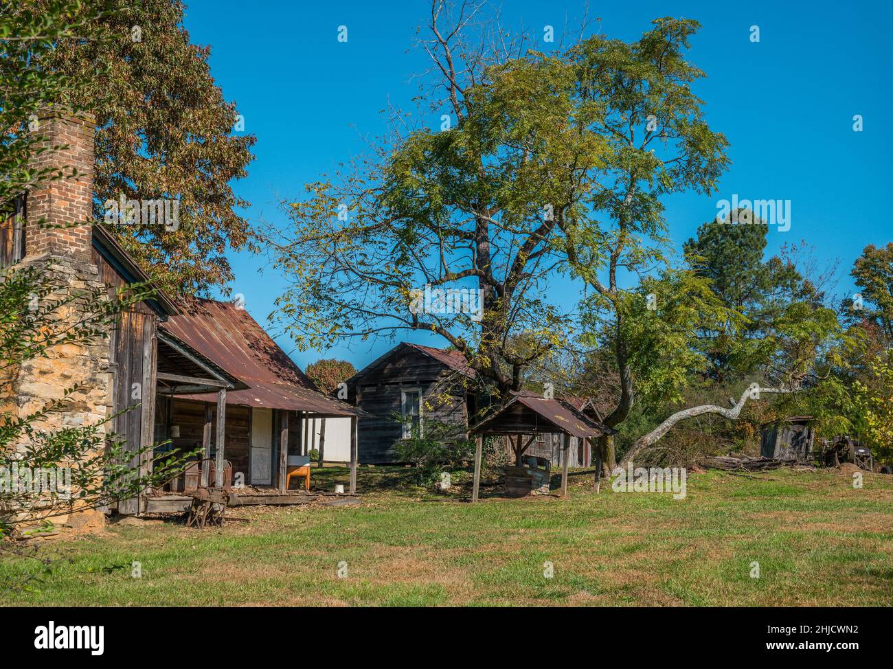 Backside of an old abandoned farmhouse and other outbuildings with a ...