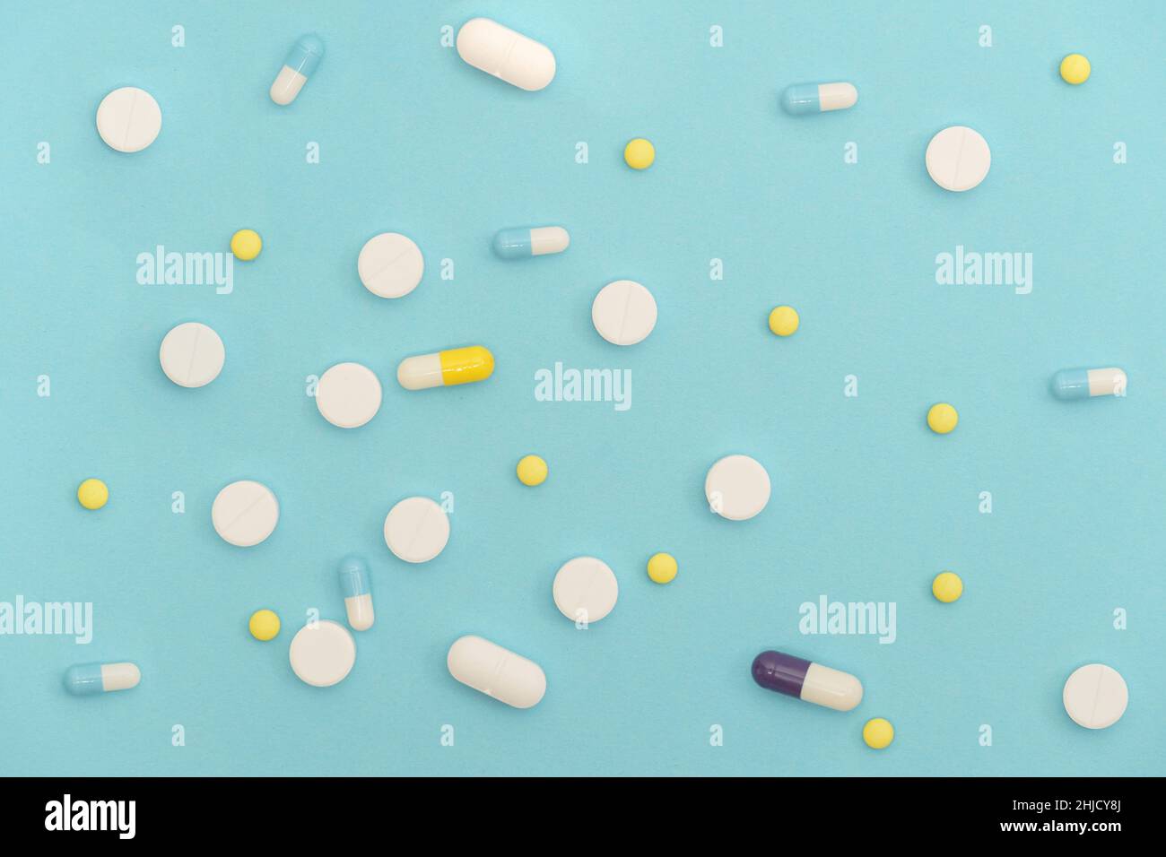 Medicine capsules, pills and tablets on light blue background ...