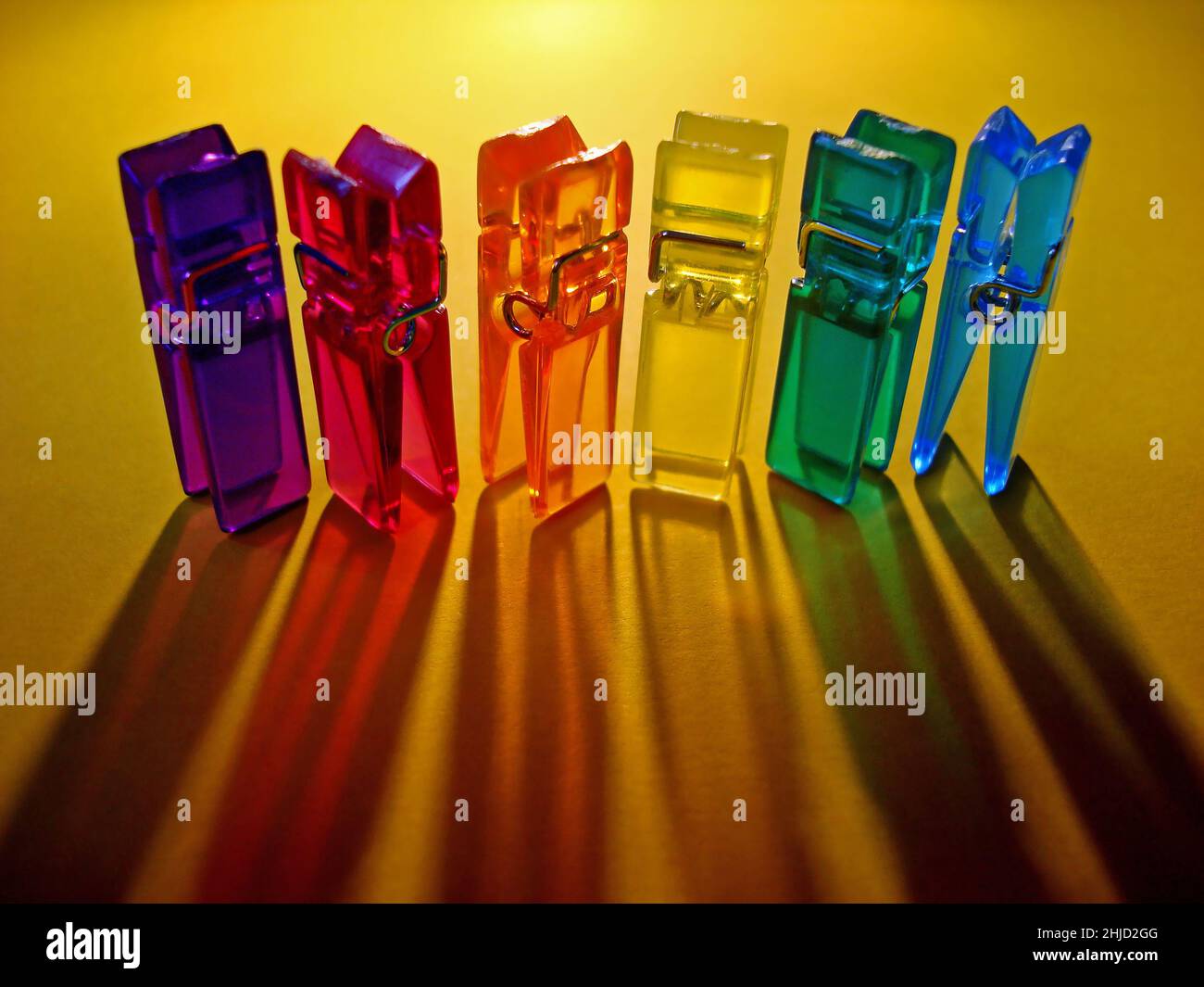 Acrylic color clothes pegs on yellow Stock Photo - Alamy