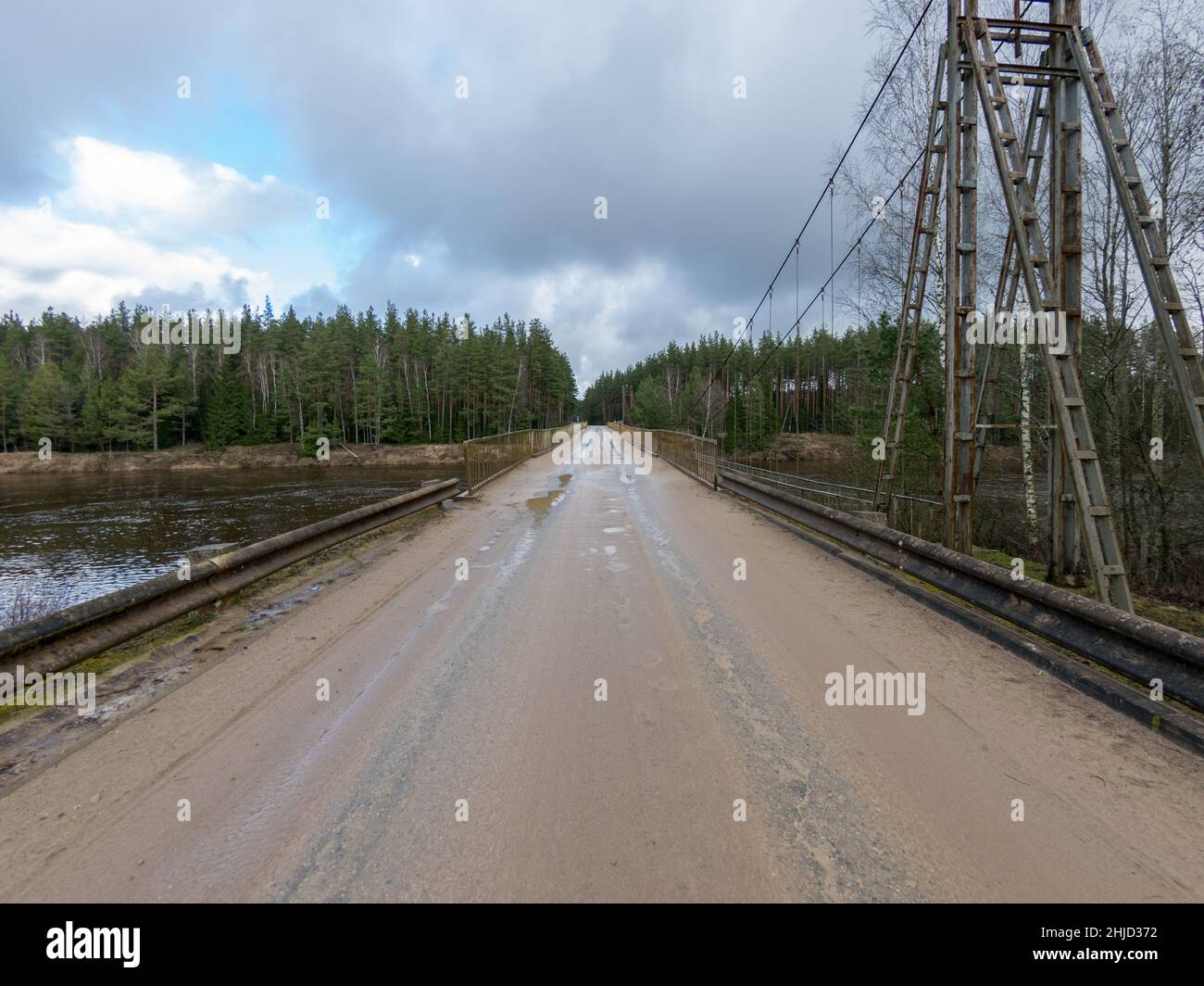 spring landscape with dirty and wet dirt road, bridge over river Stock ...