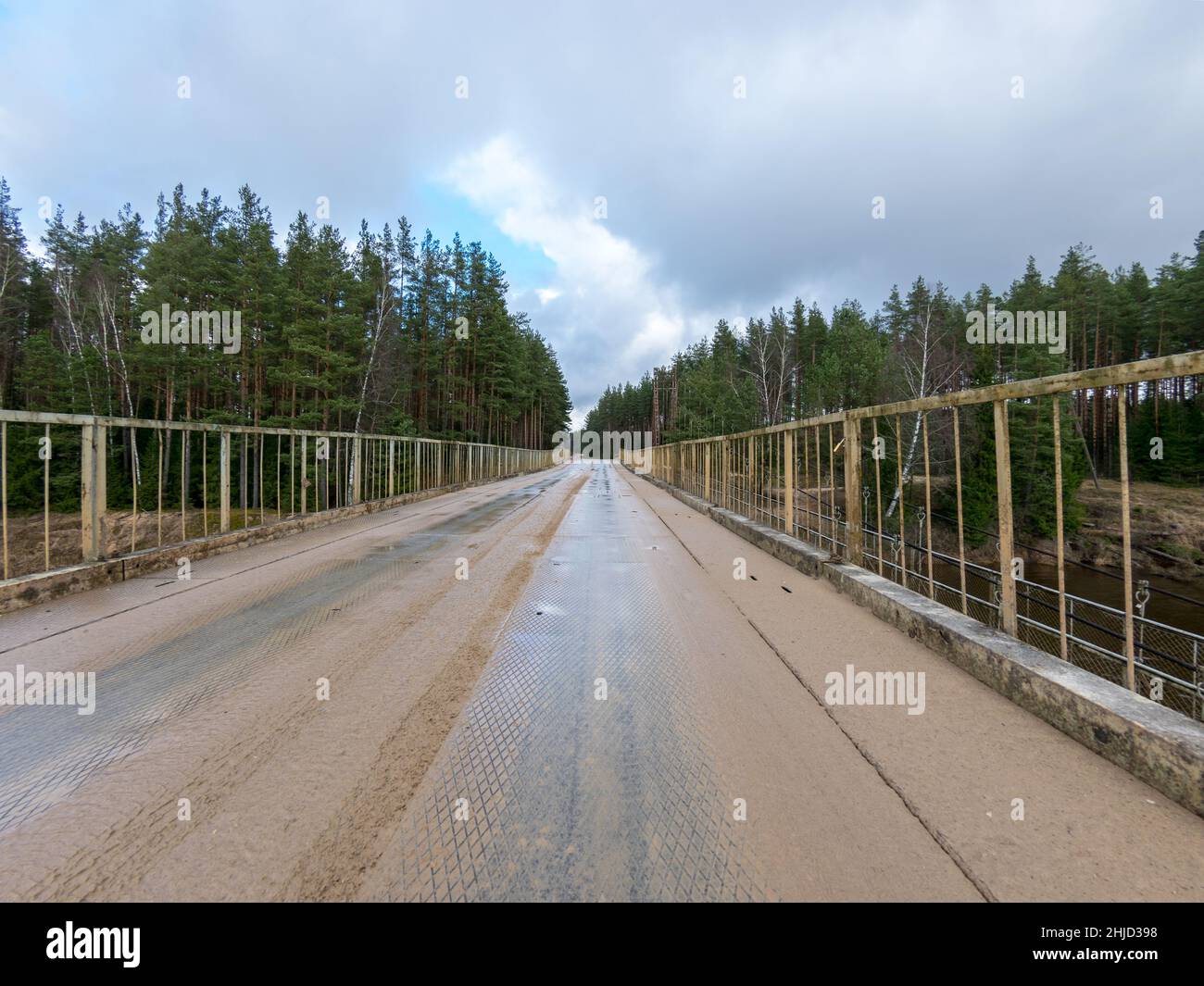 spring landscape with dirty and wet dirt road, bridge over river Stock ...