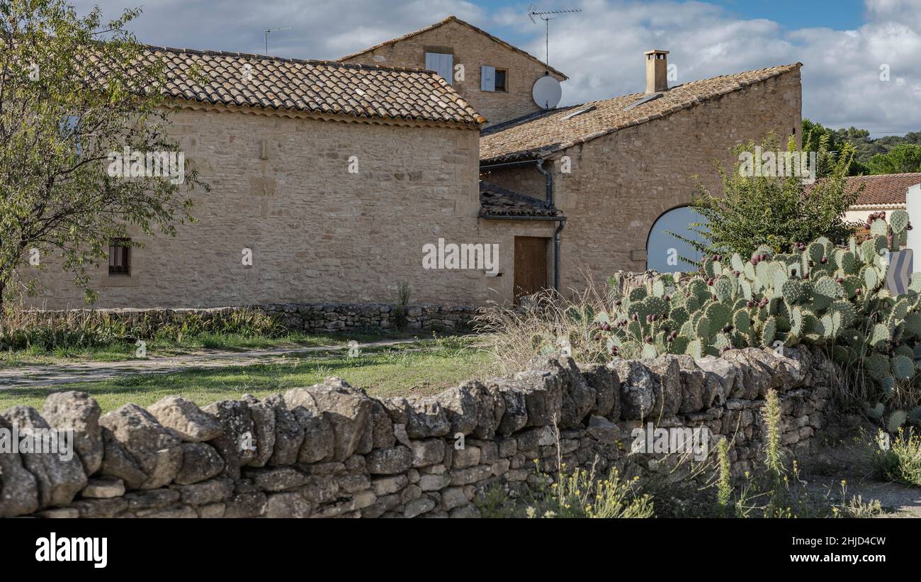 Winery building made of honey coloured stone with a large arched blue ...