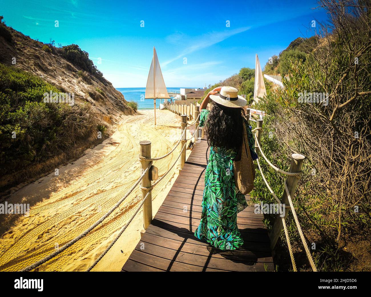 A holidaymaker walks down to the beach for a day of sun, sea and sand ...