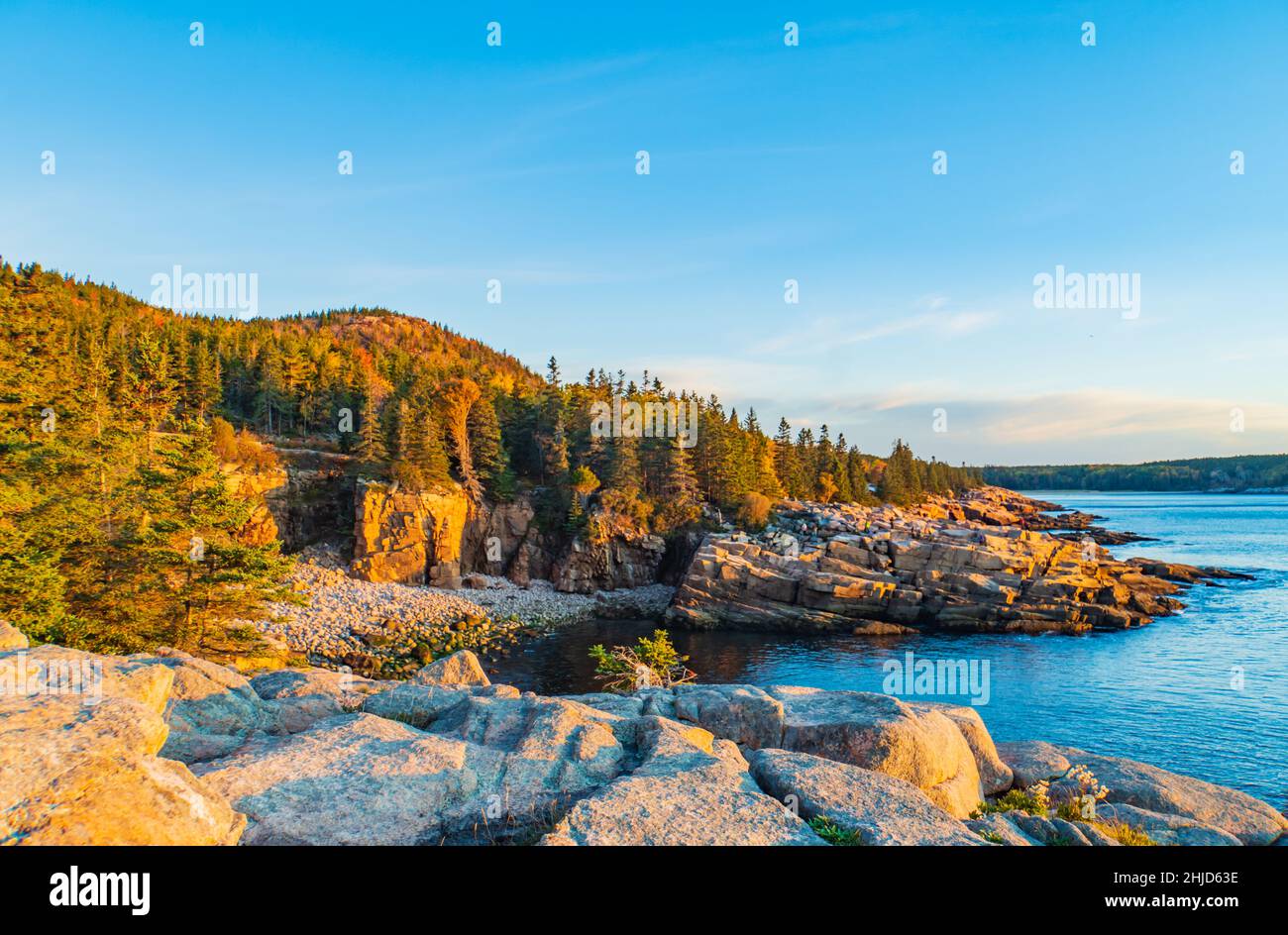 early morning sun lights up Monument Beach on the coast of Acadia ...
