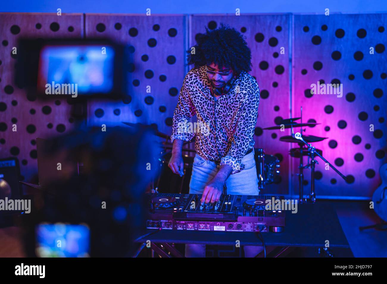 DJ playing music with mixer player in house studio while filming video ...