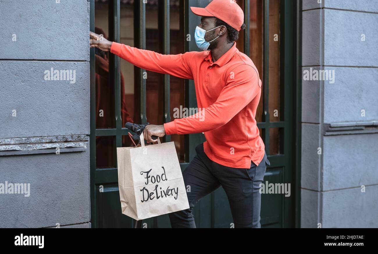 African rider man delivering meal to customers with electric scooter ...