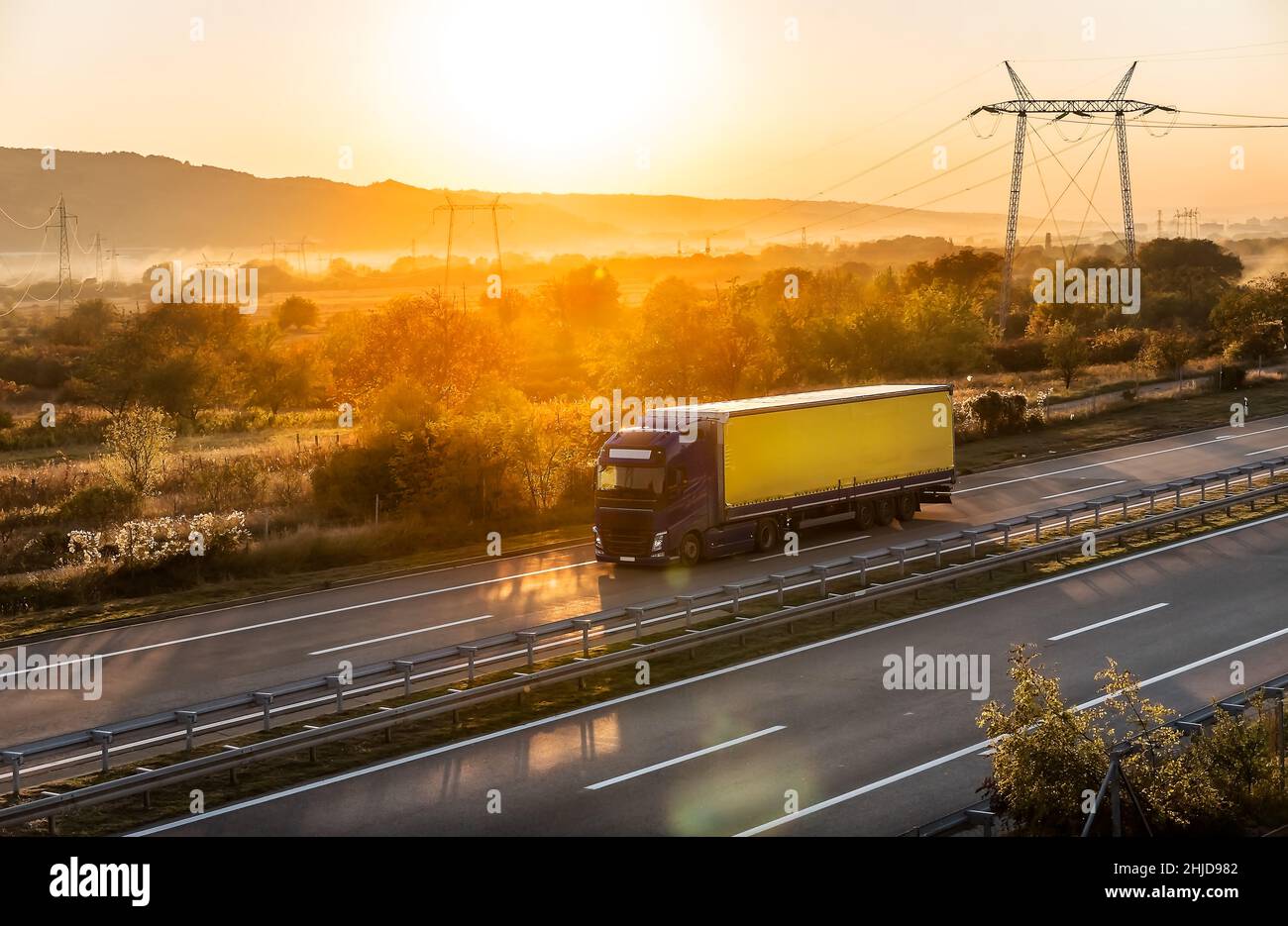 Transportation truck passing along highway in a dreamy sunset. Highway ...