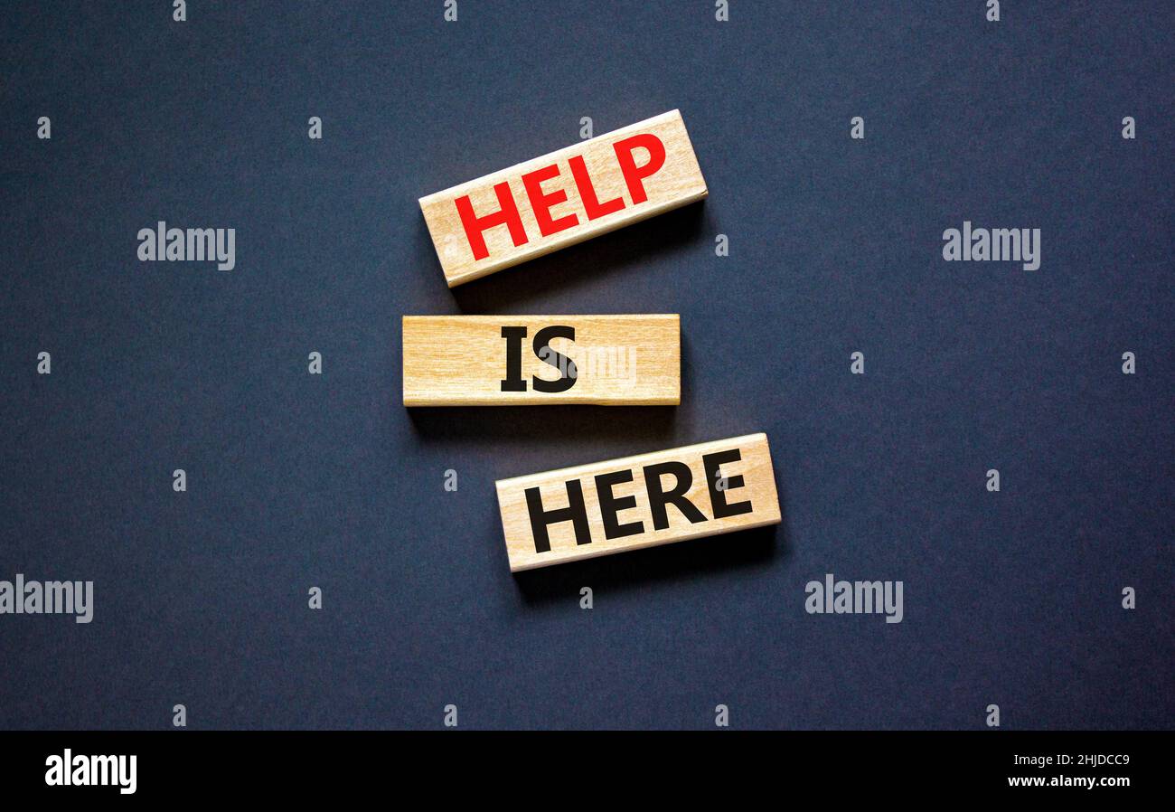Help is here and support symbol. Concept words Help is here on wooden ...