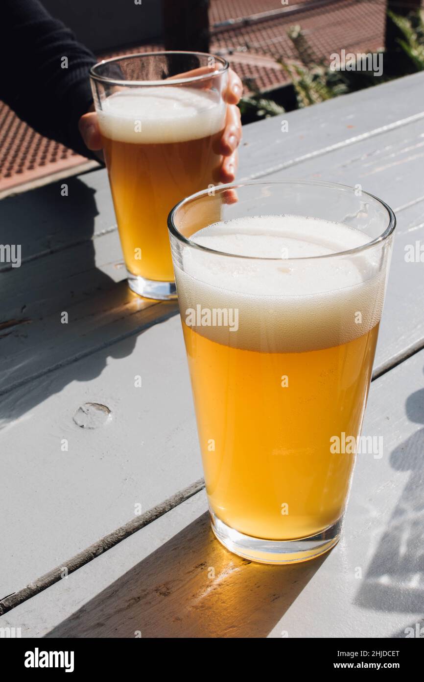 two beers on sunny picnic table outdoors Stock Photo - Alamy
