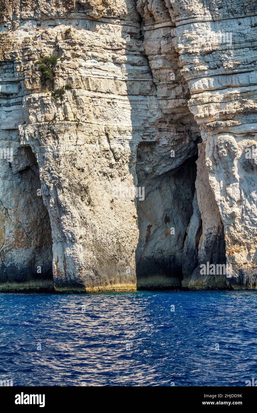 Steep cliffs with sea caves on the coast of the Greek island of Paxos ...