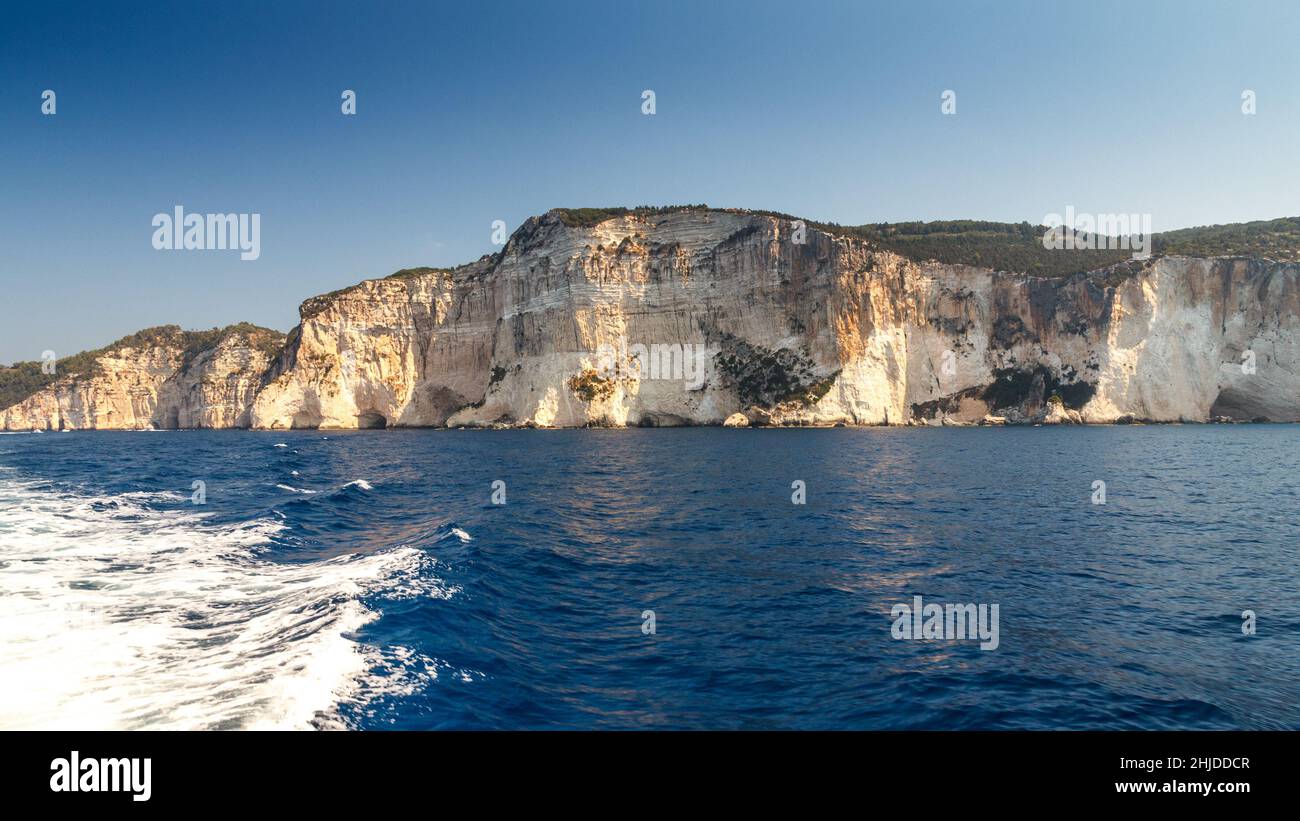 Steep cliffs with sea caves on the coast of the Greek island of Paxos ...