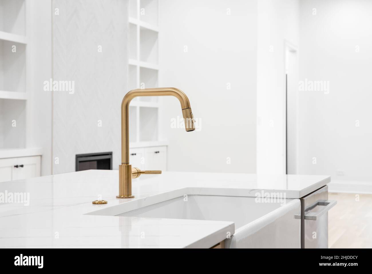 Kitchen detail shot with a farmhouse sink, gold faucet and marble ...