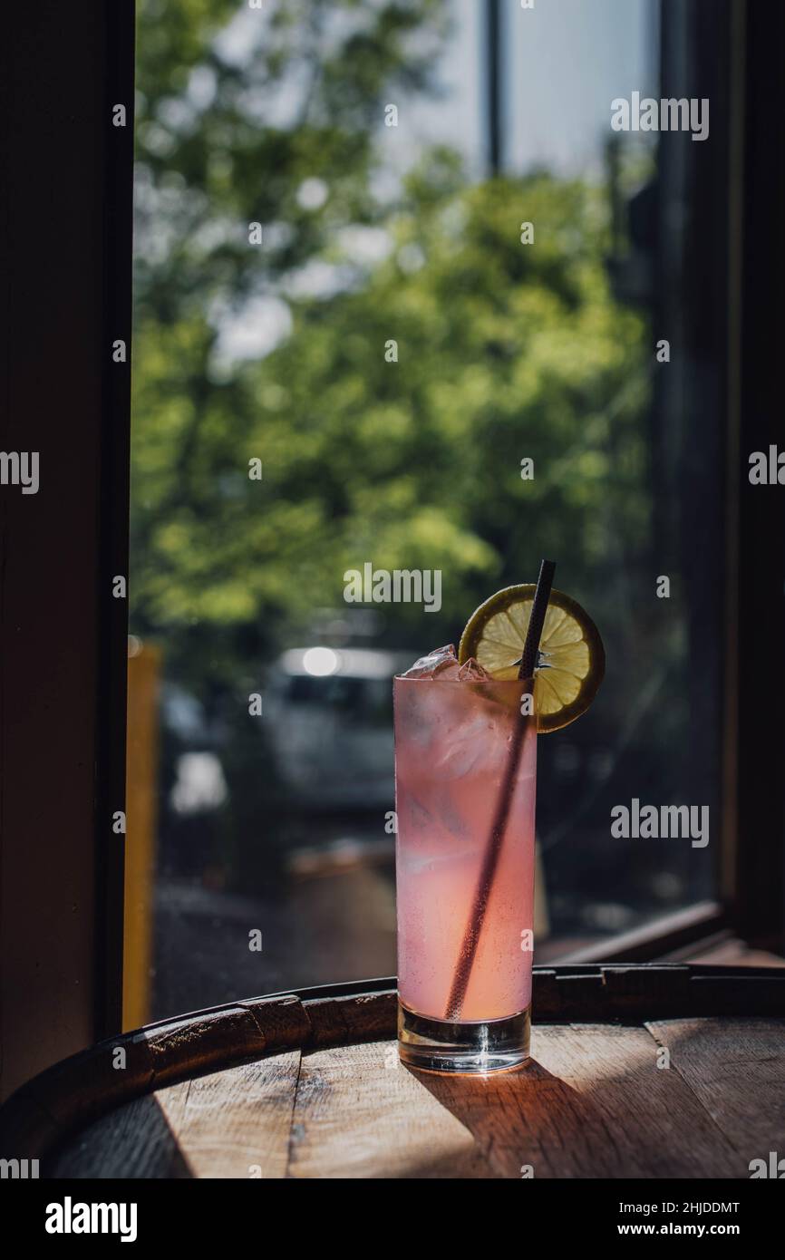 simple pink lemonade with straw and lemon wheel on window sill Stock ...