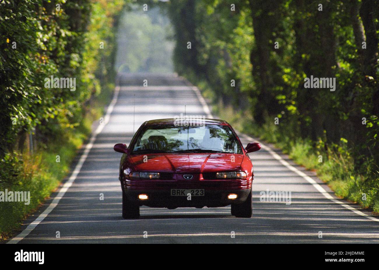 Car On Tree-lined Road Stock Photo - Alamy