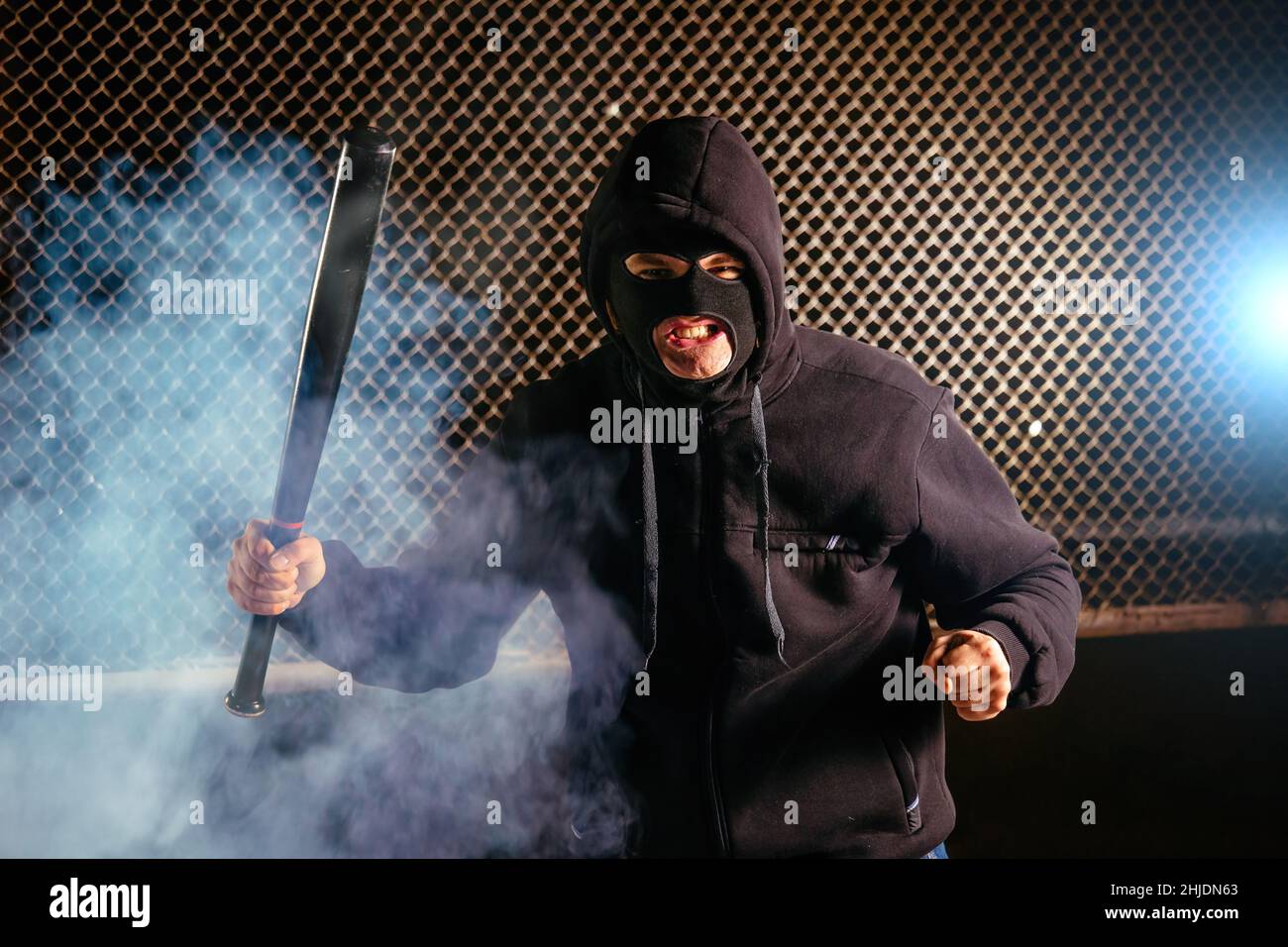 Masked angry man with bat in smoke Stock Photo - Alamy