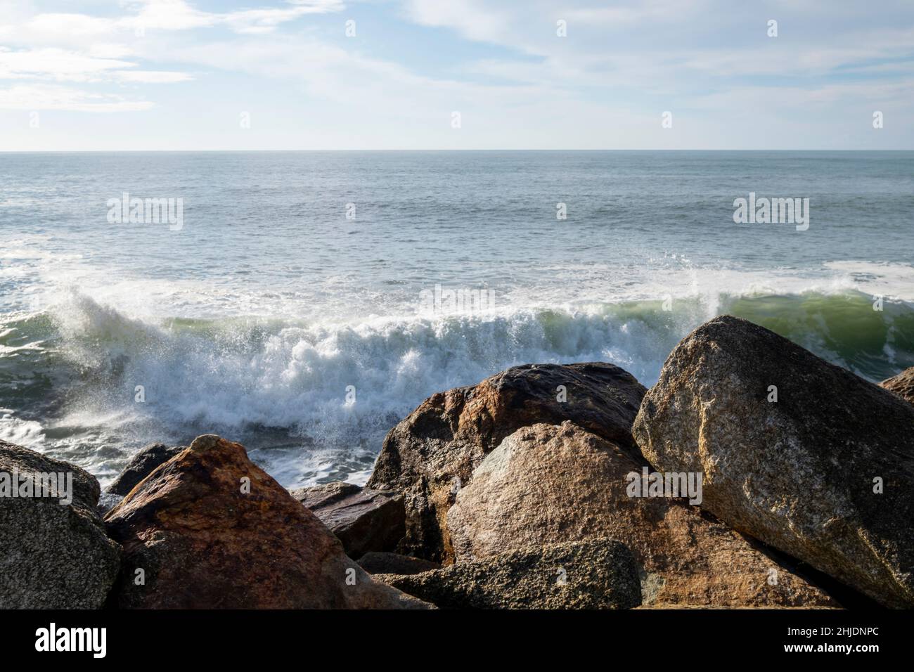 Rock barriers lined up along the beach sand to form sea wall with large ...