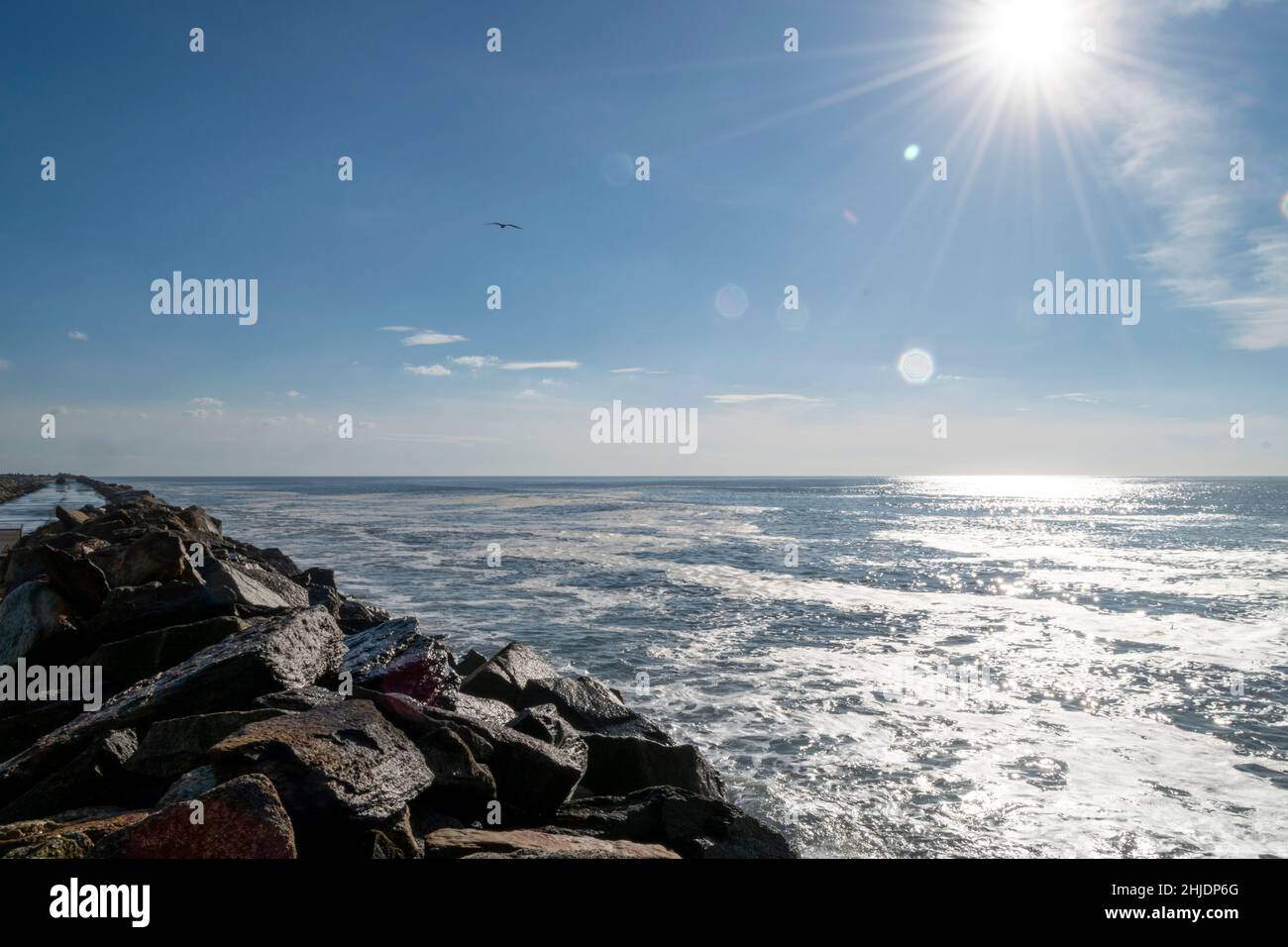 Rock barriers lined up along the beach sand to form sea wall with large ...