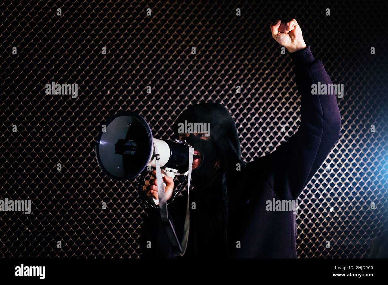 Angry masked man is shouting into the megaphone Stock Photo - Alamy